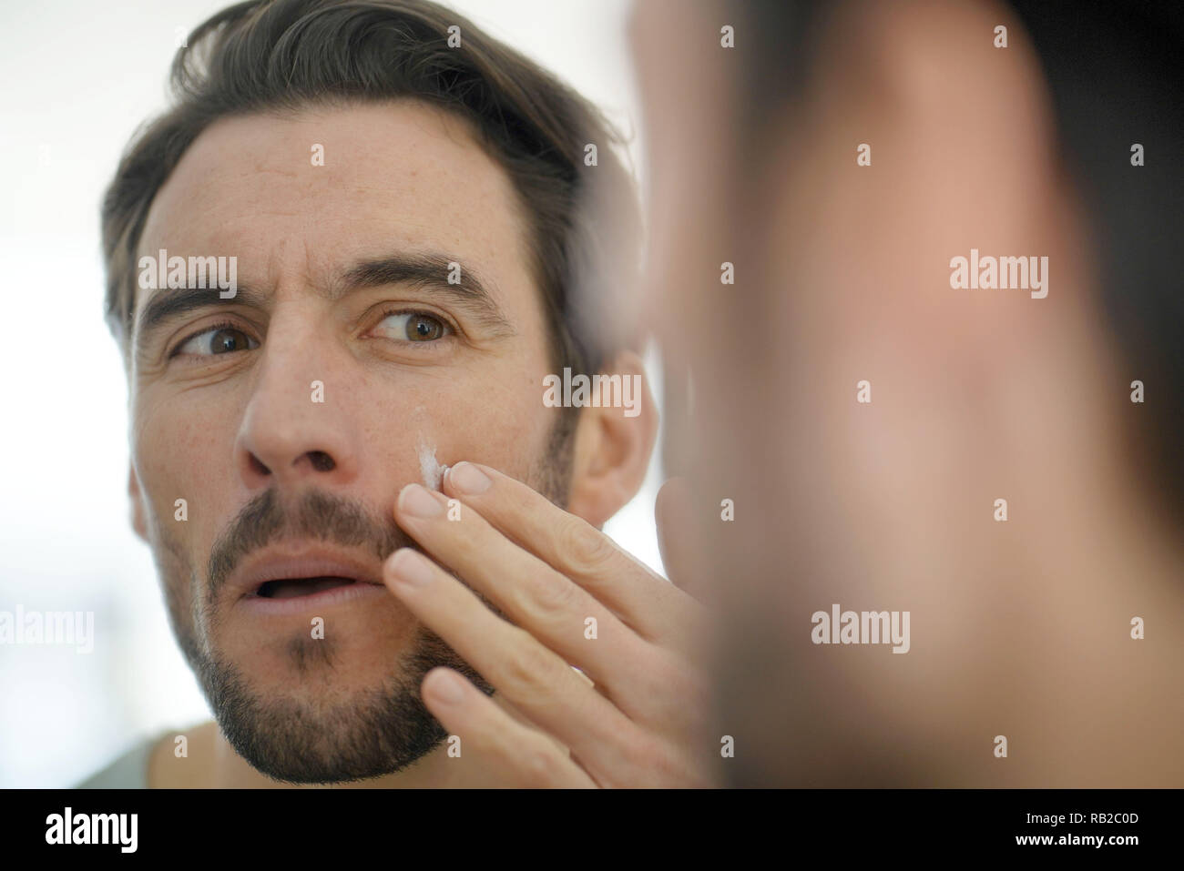Man moisturising in mirror hi-res stock photography and images - Alamy
