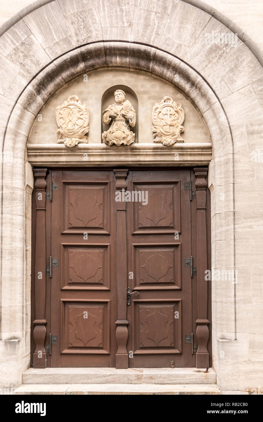 Old door of a historical building with statues and coats of arms made ...