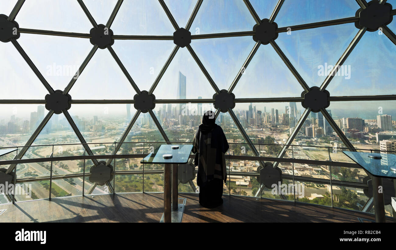 Woman looking at view of Kuwait City from viewing dome inside Kuwait ...