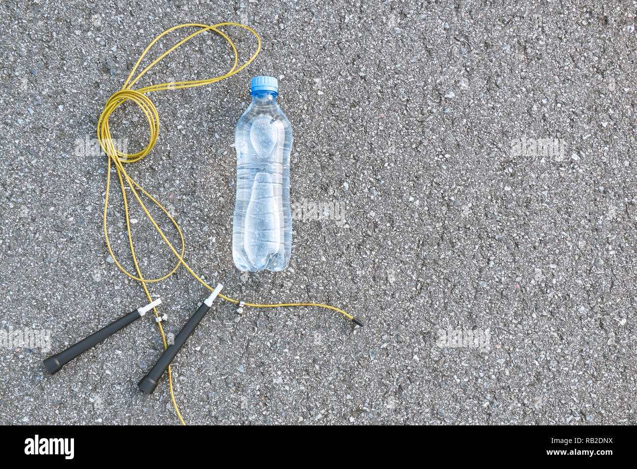 Burning fat concept. Bottle of water near the jumping rope Stock Photo ...