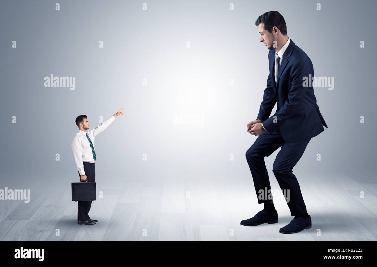 Small businessman in shirt pointing to an afraid businessman Stock ...