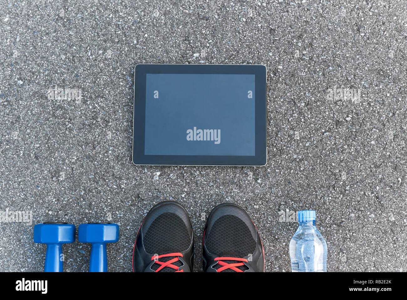 Smart sports gadgets. Cropped photo of dumpbells, water and black ...