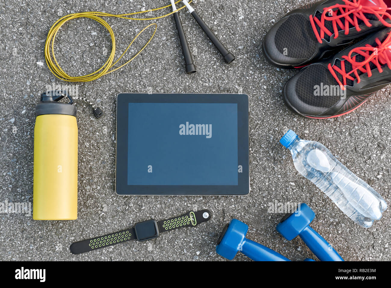 Smart sports gadgets. Cropped photo of dumpbells, water, jumping rope ...