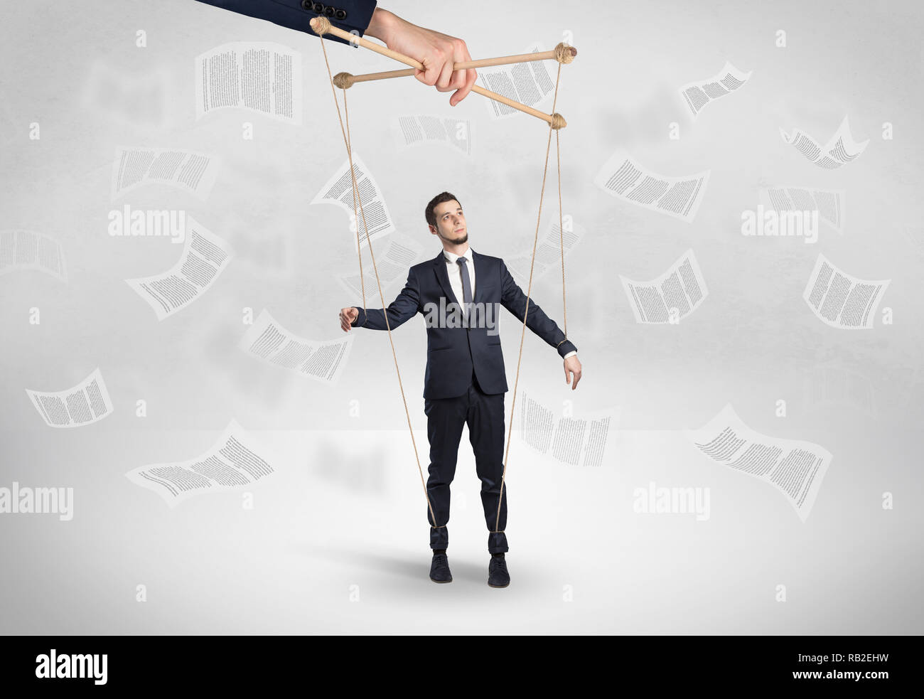 Puppet employee controlled by a big hand with documents and staffs ...