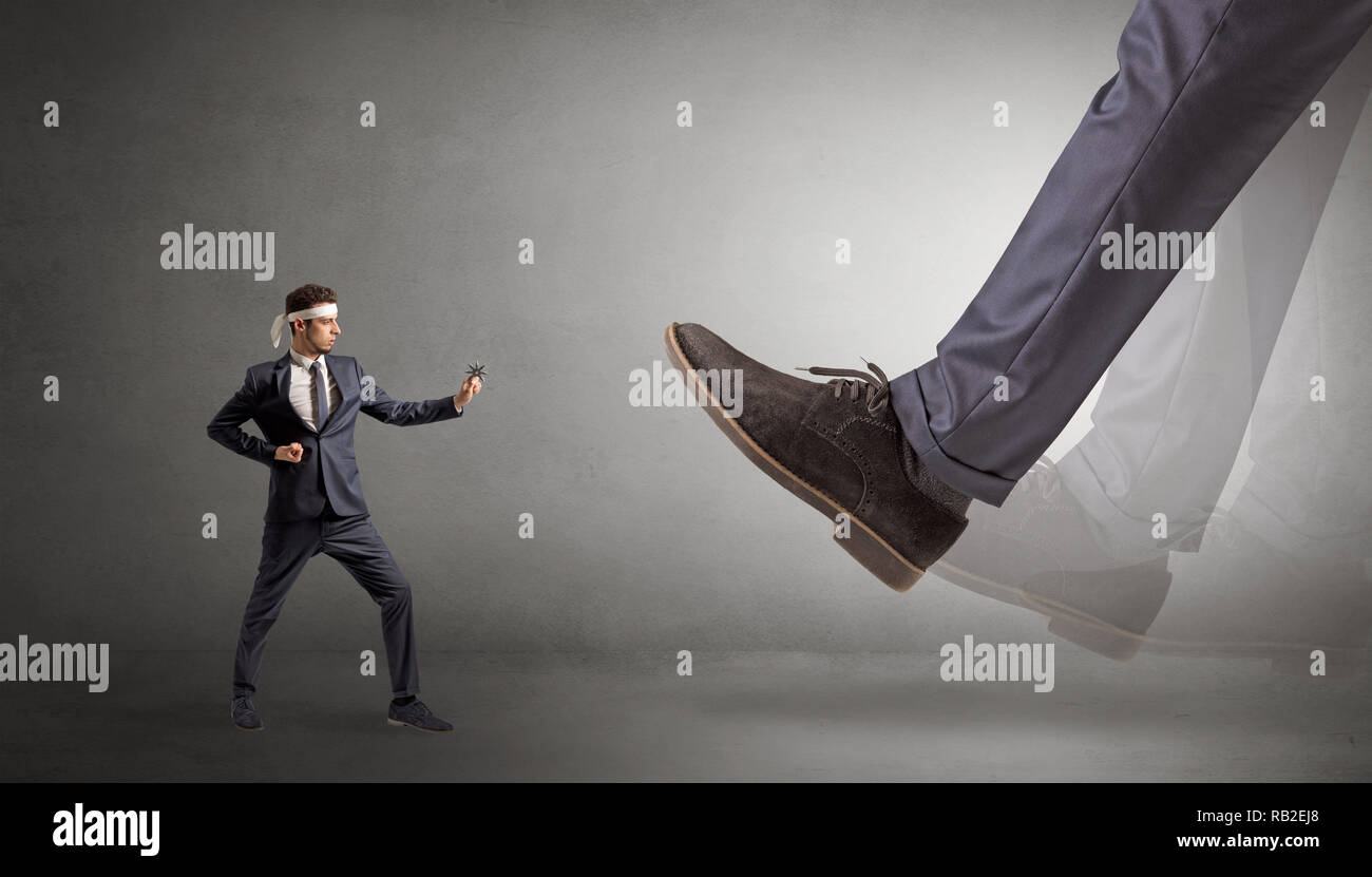 Big foot treading small young karate man Stock Photo - Alamy