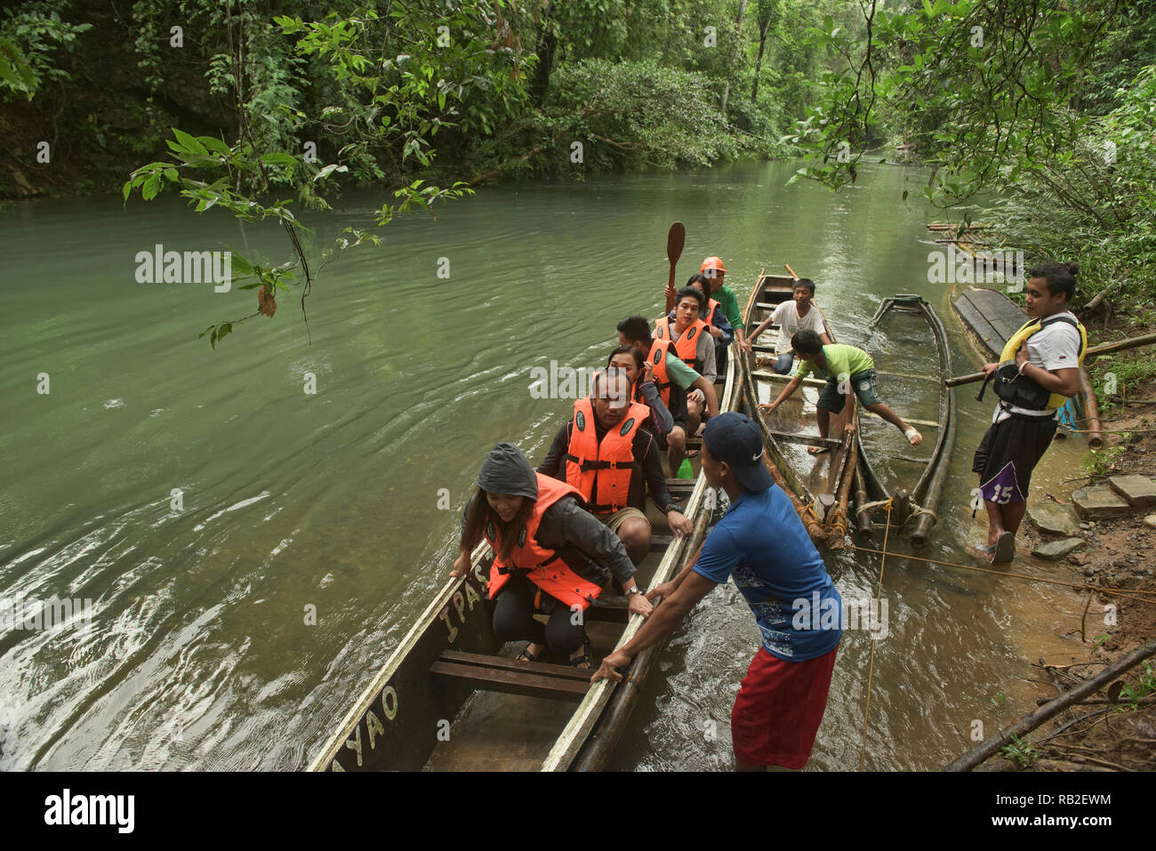 Tourists preparing to paddle to the Lussok Cave and underground river ...