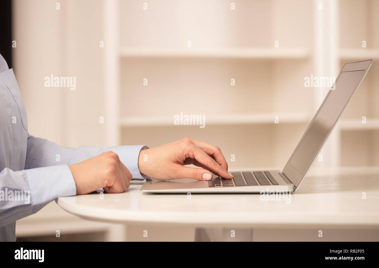 Business woman below chest working on her laptop in a cozy environment ...