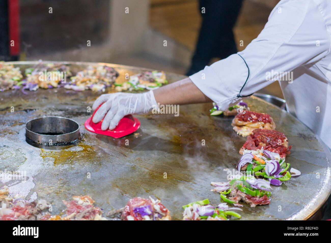 Cooking street food on a large firebox. Frying meat and seafood on the ...