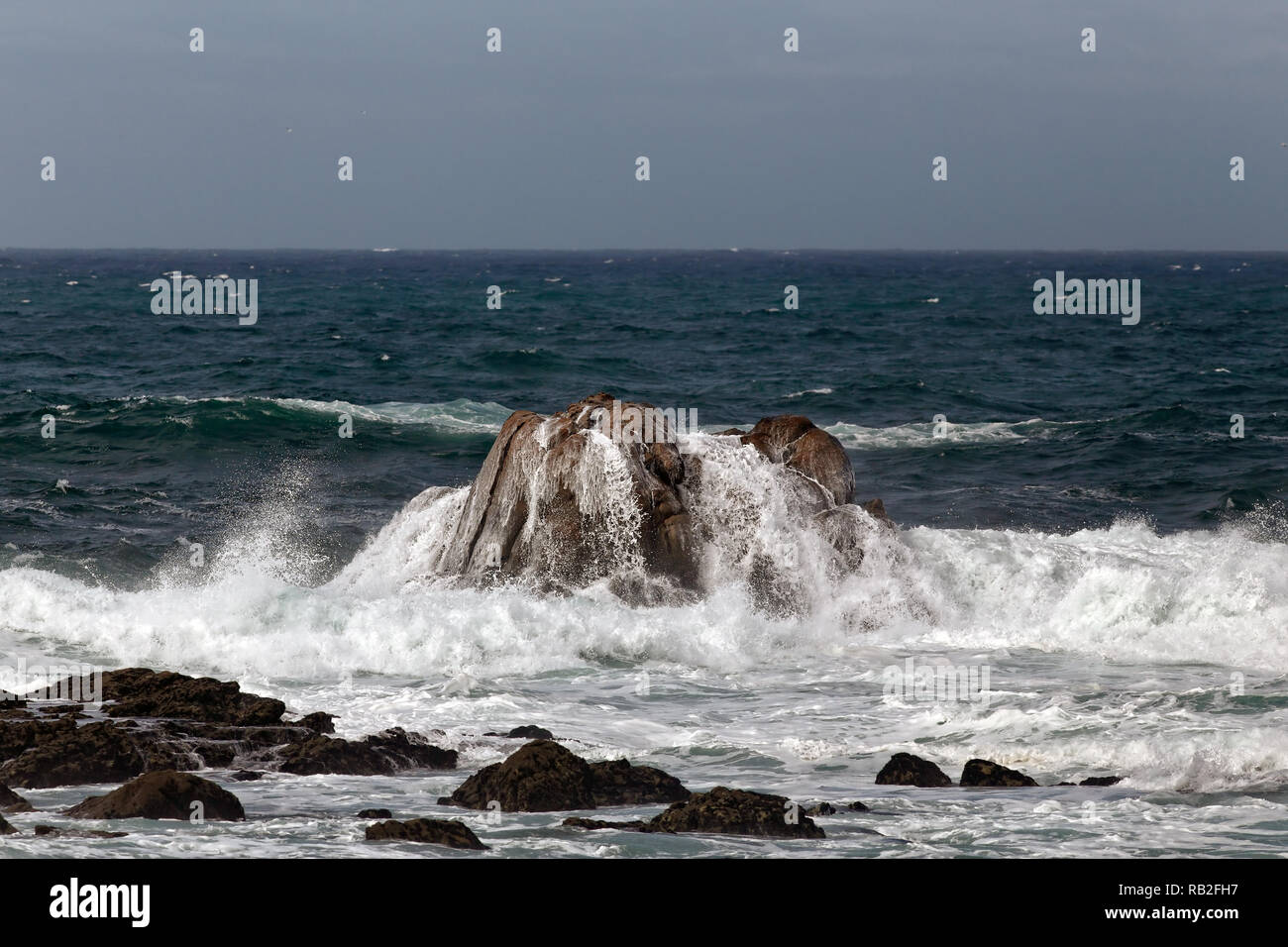 Boulder being buffeted by big waves in the Portuguese coast Stock Photo ...