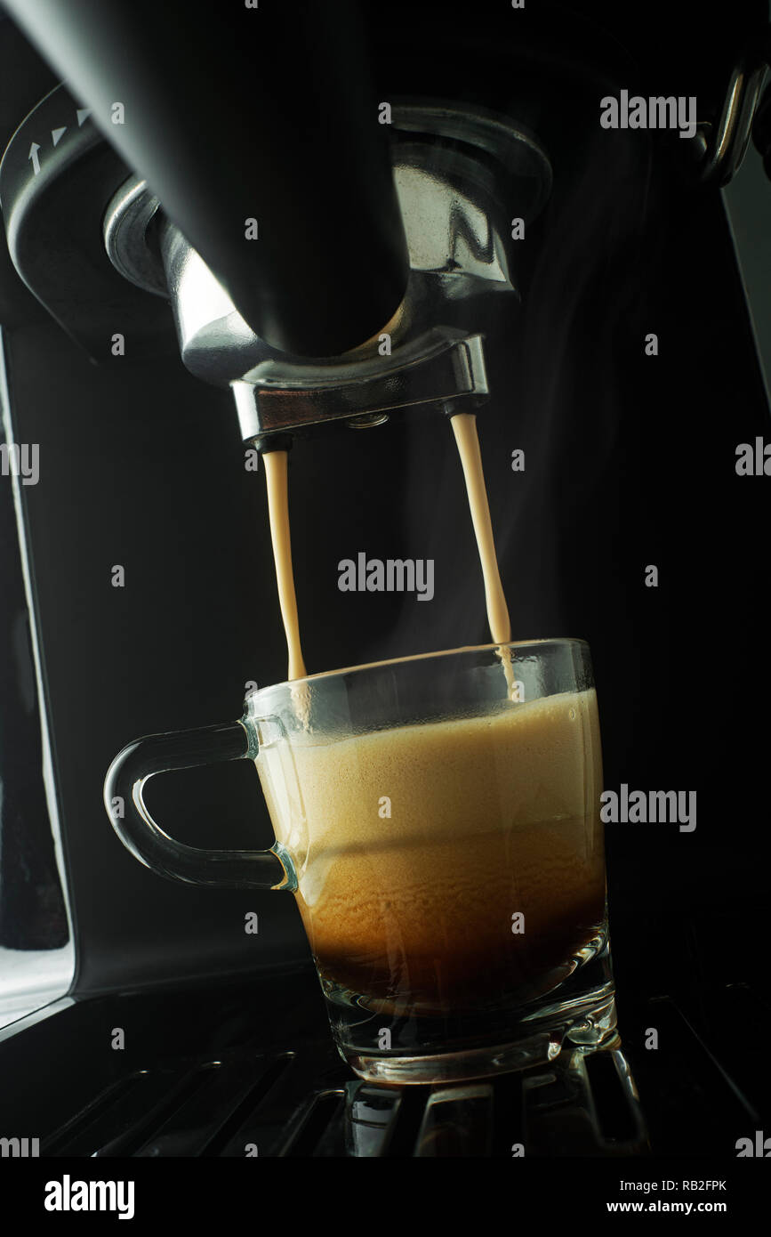 Espresso coffee pouring from coffee machine. Professional coffee ...