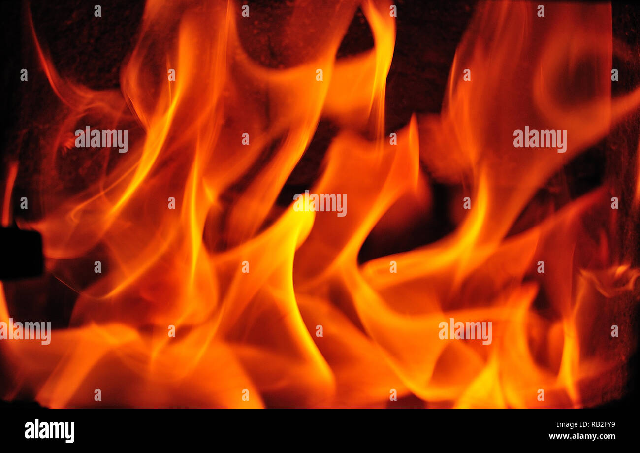 close-up of burning fire with yellow and red flames in cast iron ...
