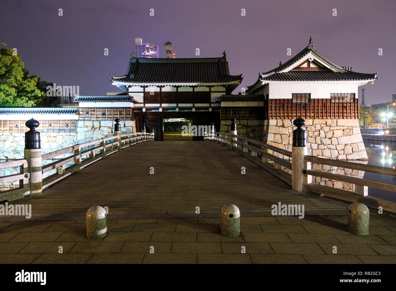 Reconstructed Hiroshima castle at night. Bridge across the moat leading ...