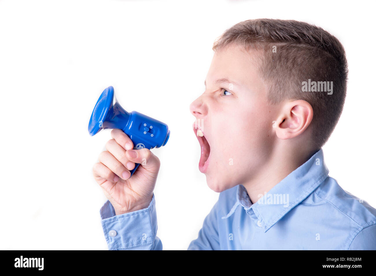 Boy shouting very loudly into a small blue megaphone with open mouth ...