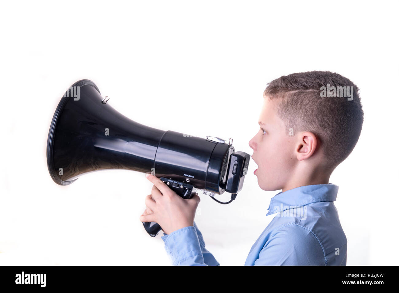 Boy calls in a black megaphone with blue shirt Stock Photo - Alamy