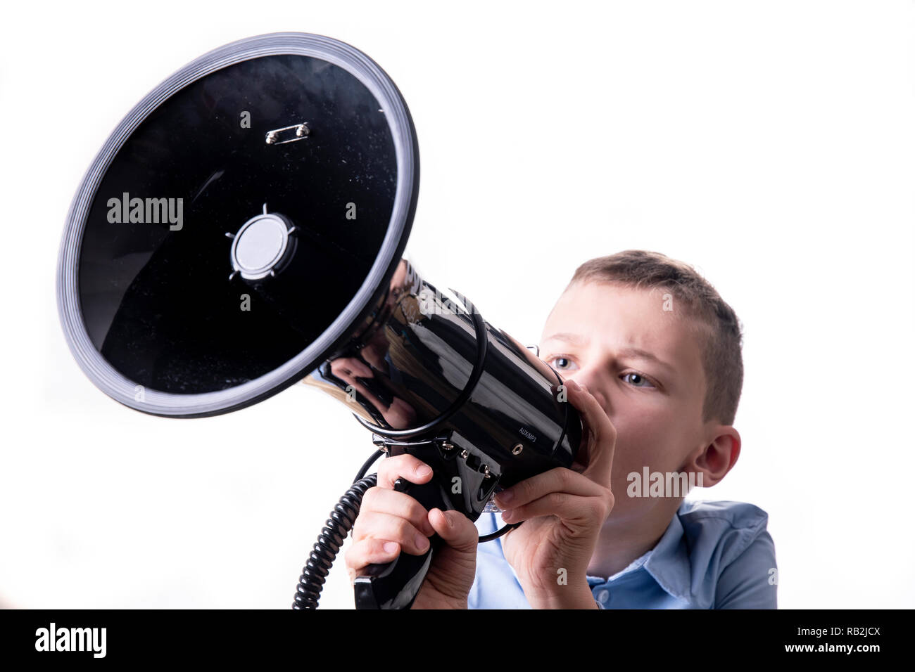 Boy calls in a black megaphone with blue shirt Stock Photo - Alamy