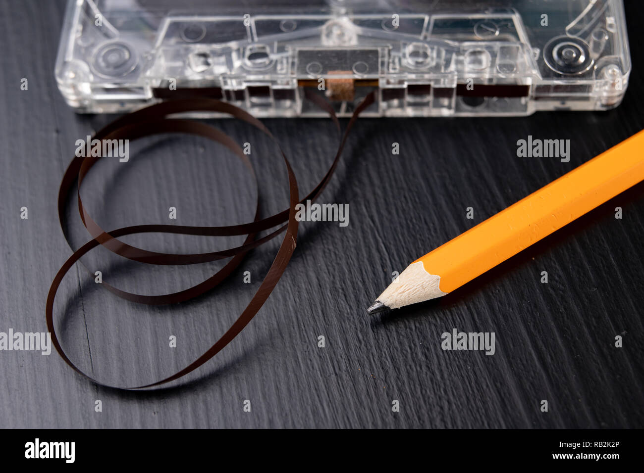 Audio Cassette And Pencil On A Black Table Old Magnetic Data Carrier Dark Background Stock
