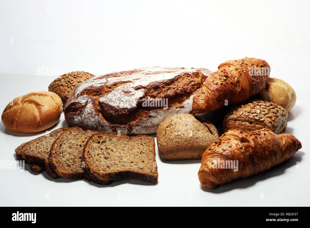 Different kinds of bread and bread rolls on board from above. Kitchen ...