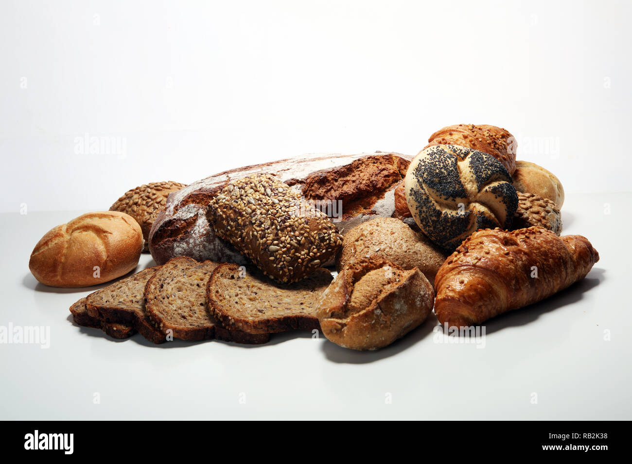 Different kinds of bread and bread rolls on board from above. Kitchen ...
