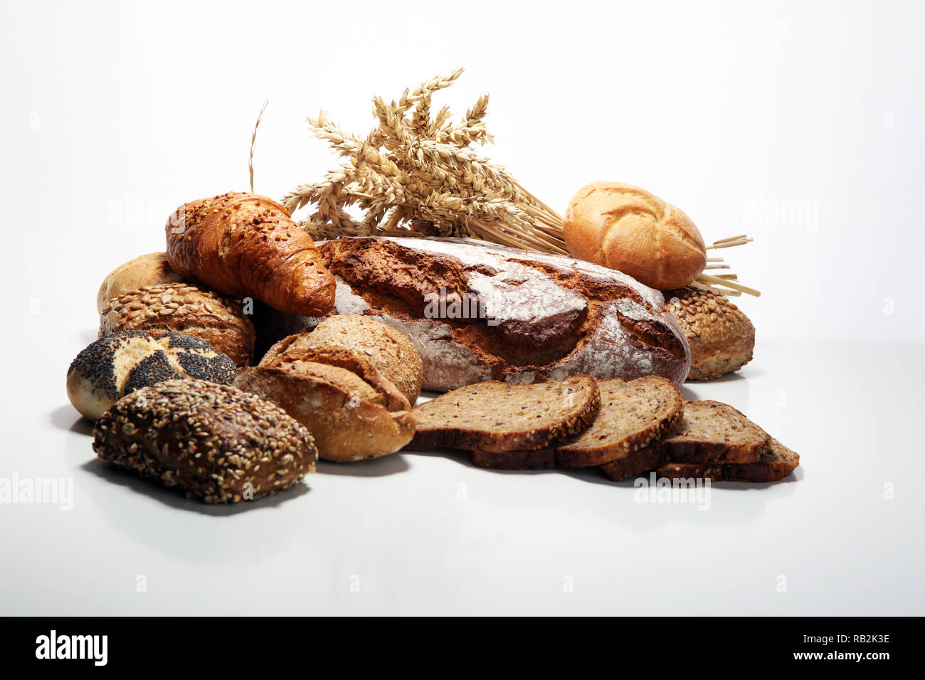 Different kinds of bread and bread rolls on board from above. Kitchen ...