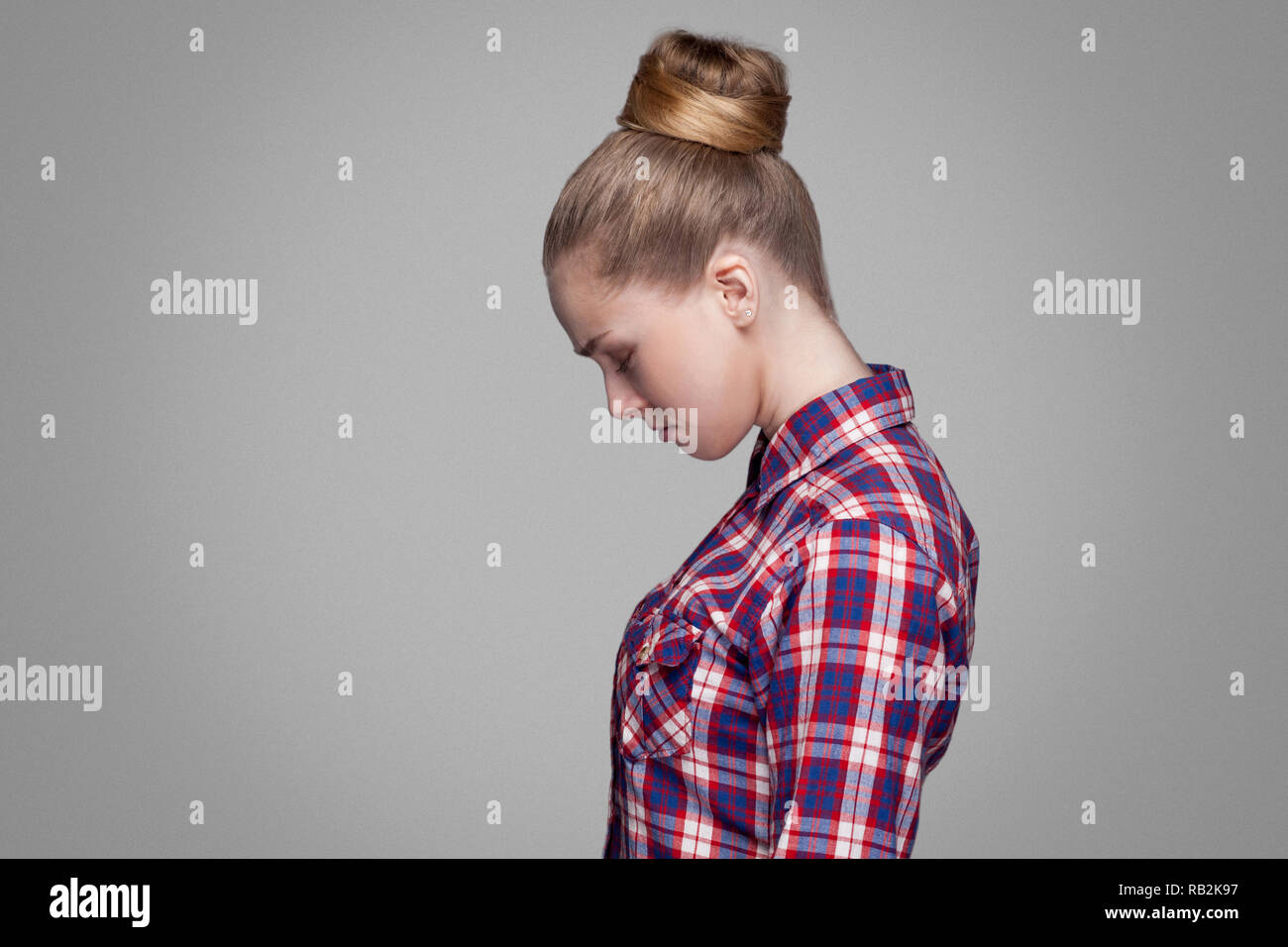 profile side view of sad beautiful blonde girl in red, pink checkered ...