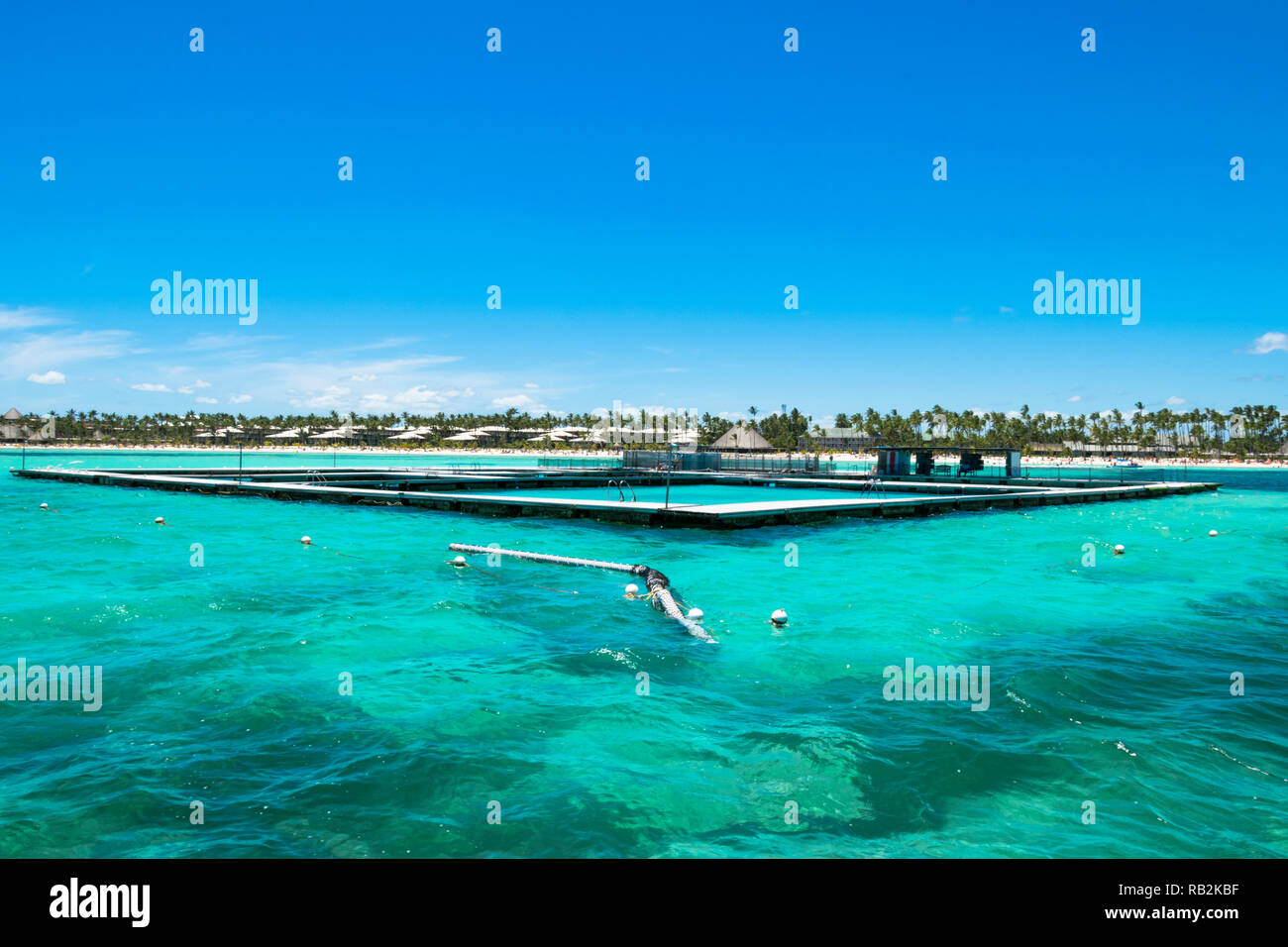 fish farm in the turquoise ocean with small waves, blue sky background ...