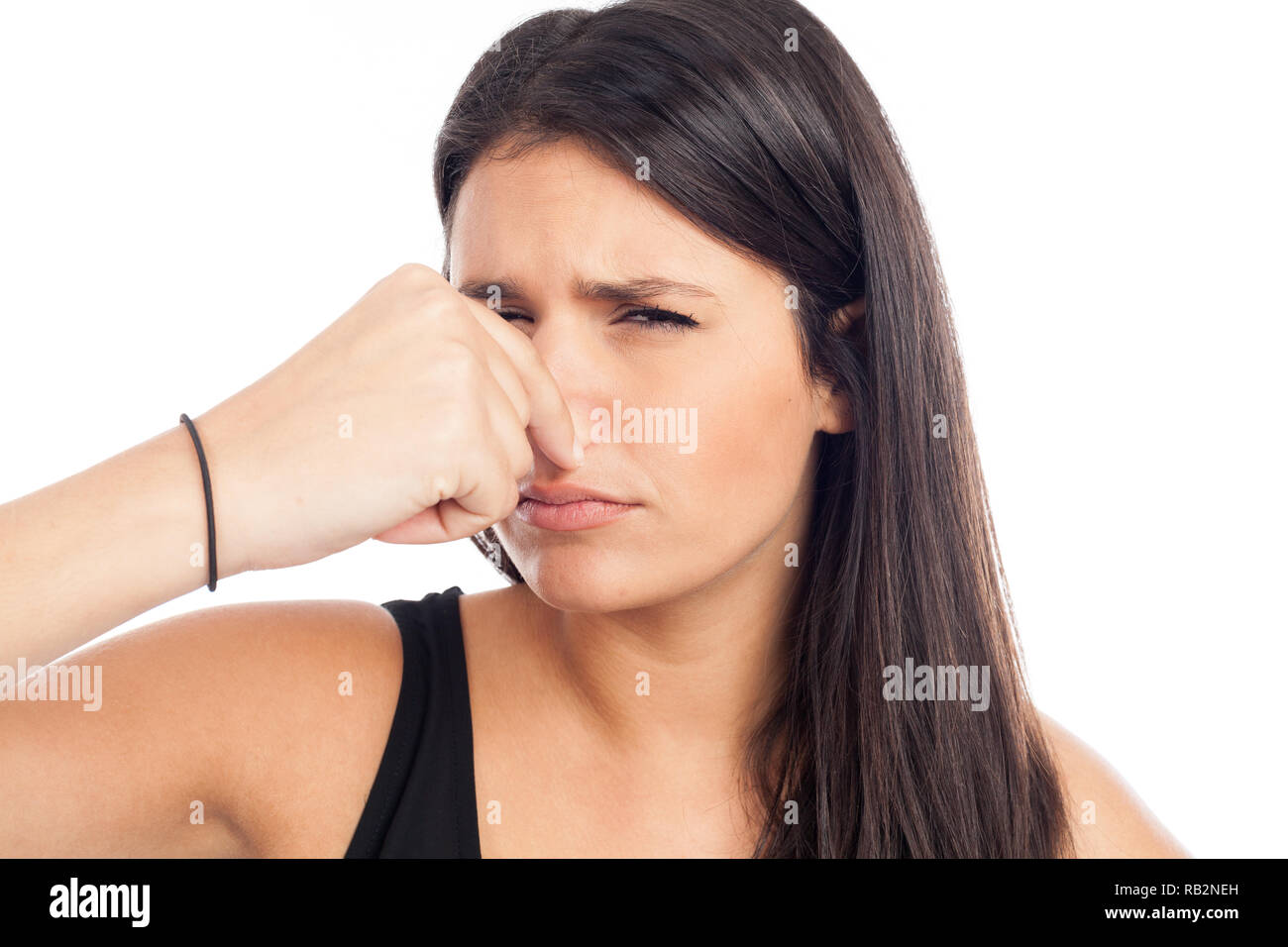 portrait of a brunette woman pinching her nose because of a bad smell ...