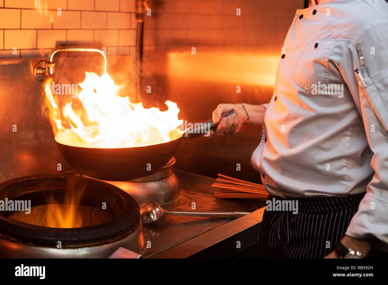 A man cooks cooking deep fryers in a kitchen fire. Process of food ...