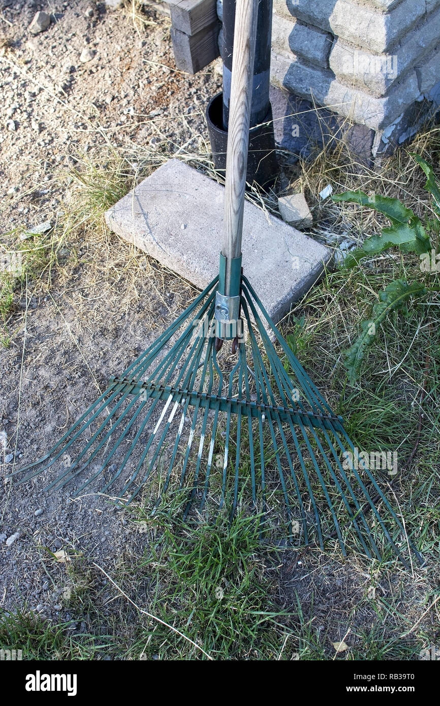 Green rake gardening equipment on bad lawn Stock Photo - Alamy