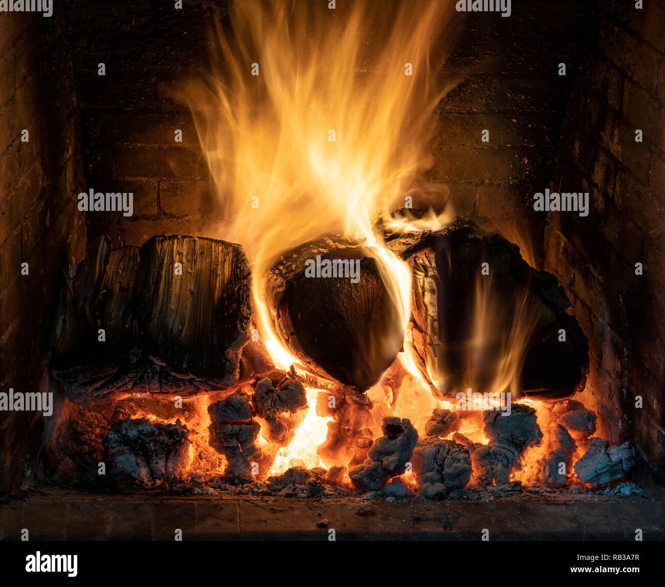 A blazing log fire in an open fireplace Stock Photo - Alamy