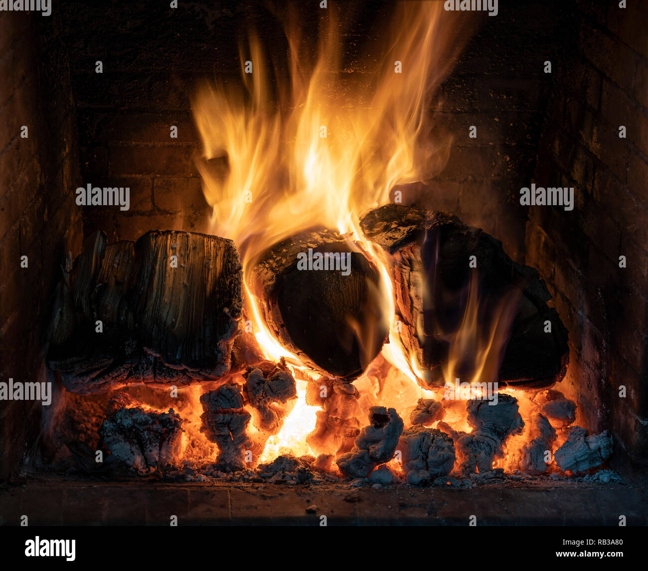 A blazing log fire in an open fireplace Stock Photo - Alamy