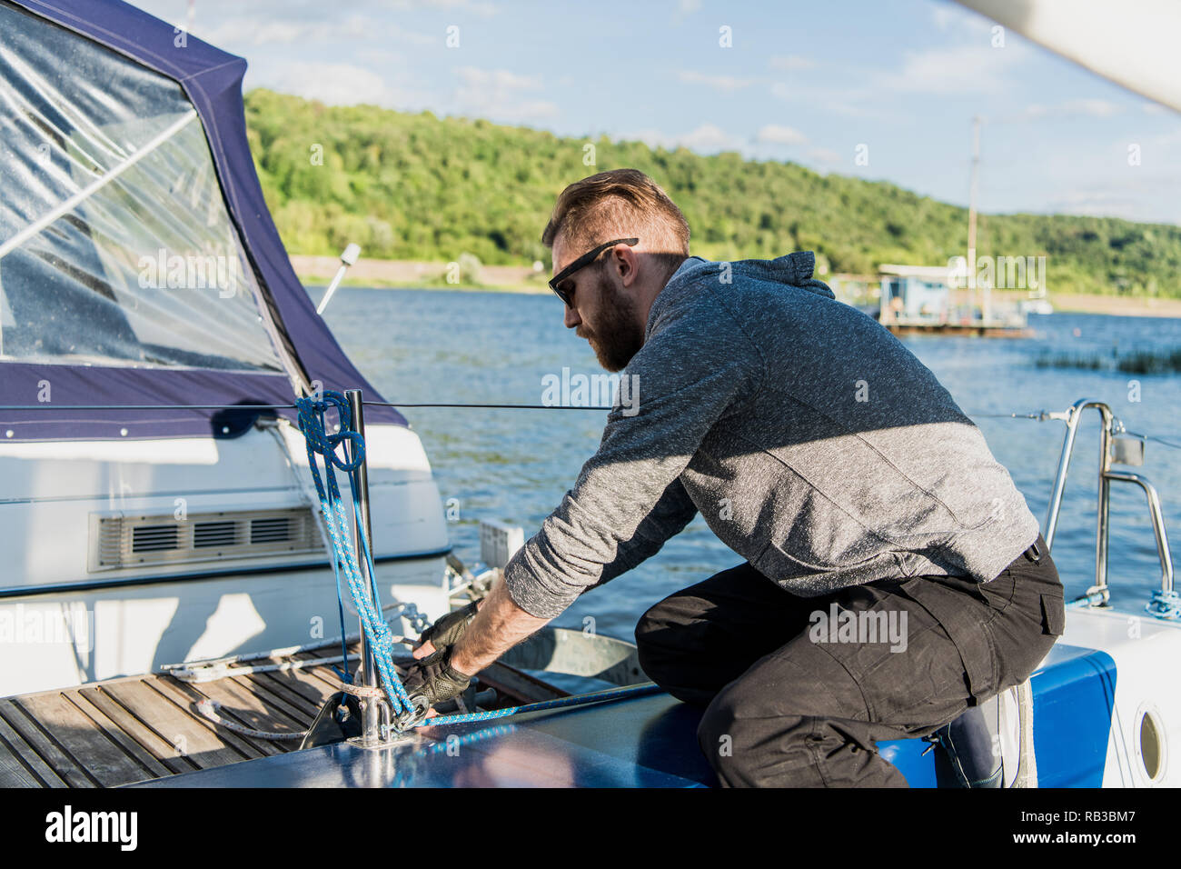 Young man lifting the sail of catamaran during cruising Stock Photo - Alamy