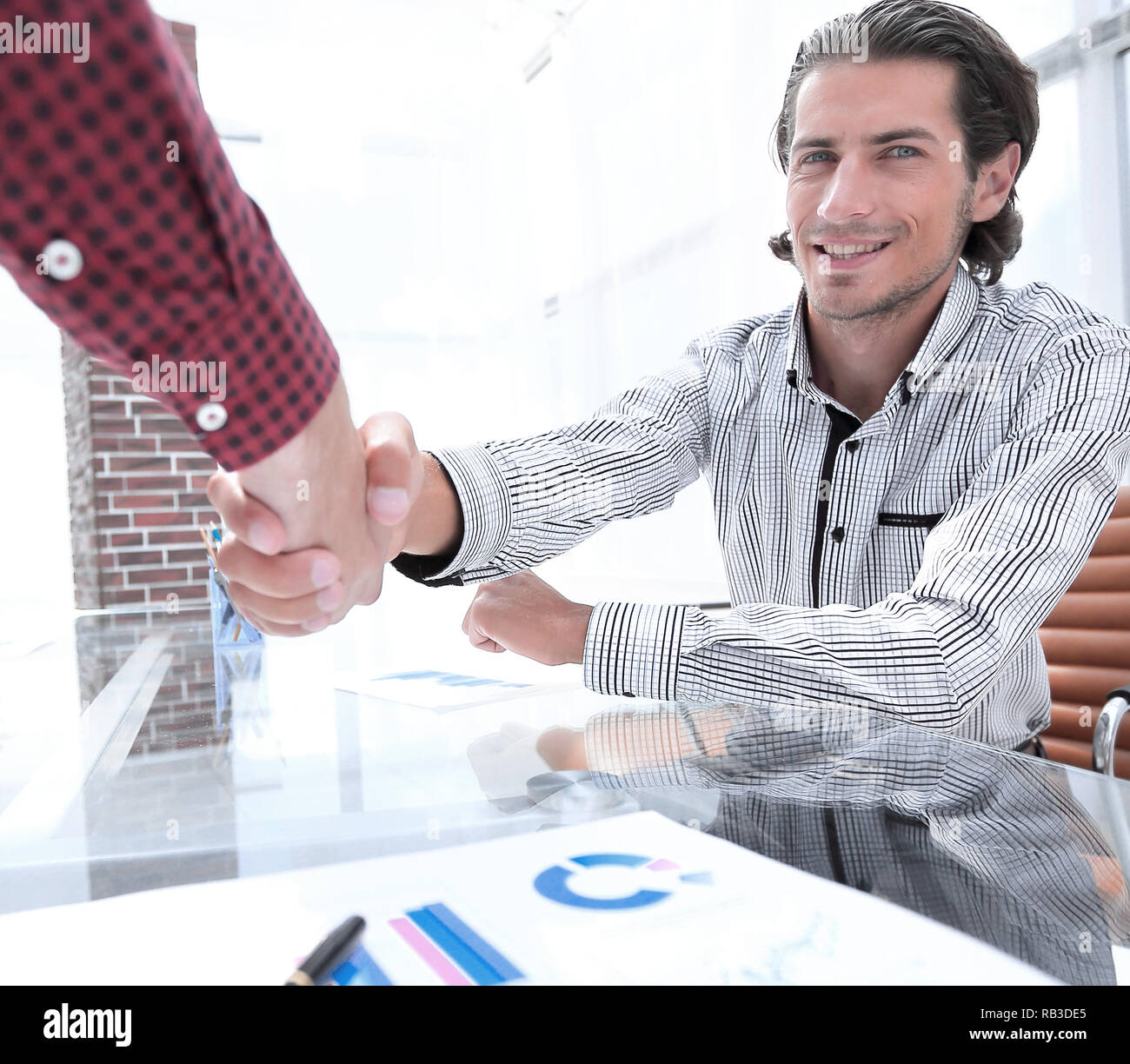 colleagues shaking hands over Desk Stock Photo - Alamy