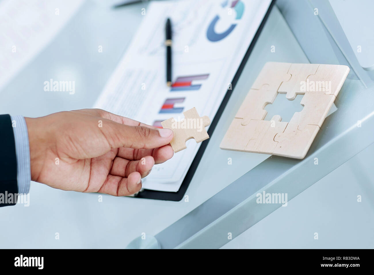 closeup. the businessman is a puzzle,sitting behind a Desk Stock Photo ...