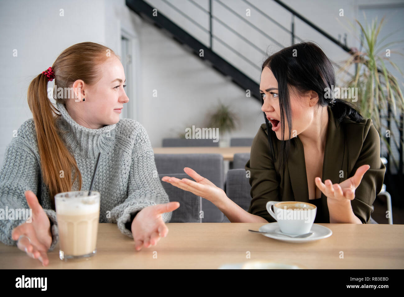 Two women are arguing in cafe. Shouting and gesturing Stock Photo - Alamy