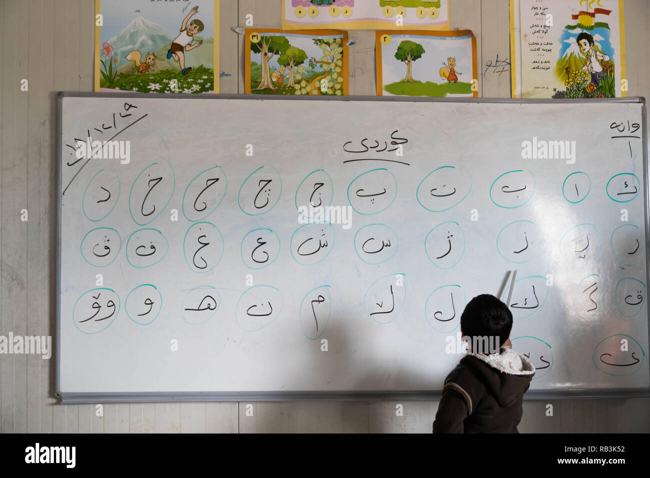A Yazidi child seen learning the Kurdish letters at the school in the ...