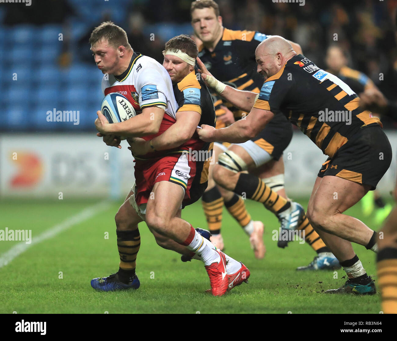 Northampton's James Fish is tackled Wasps' Jake Cooper-Woolley and ...