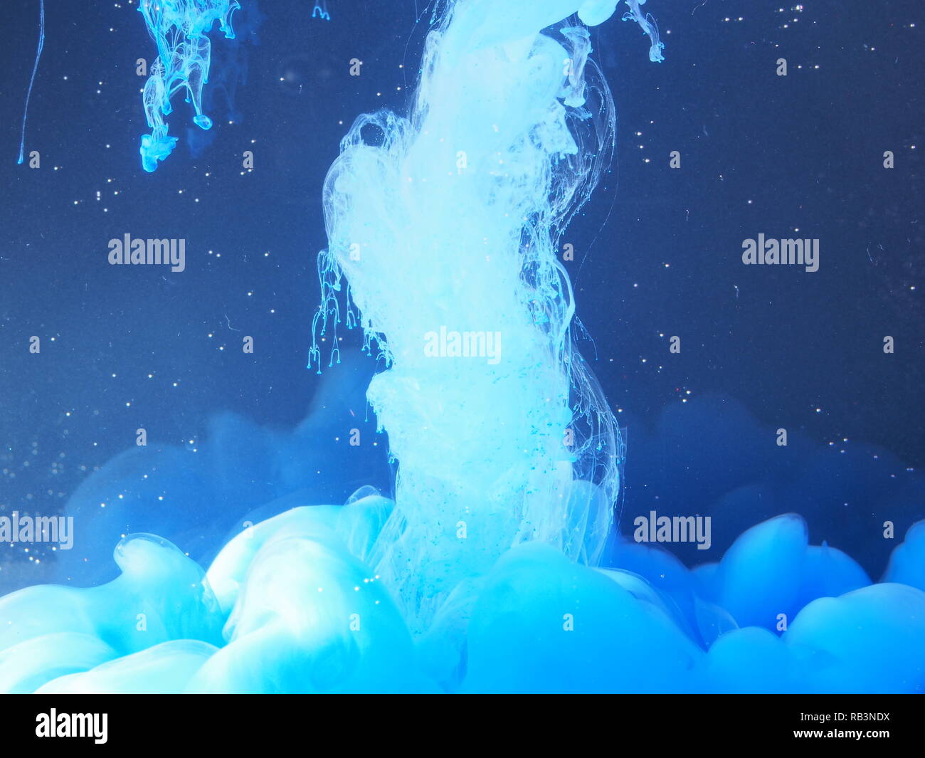 Blue paint is mixed with water. The dissolution of ink in water ...