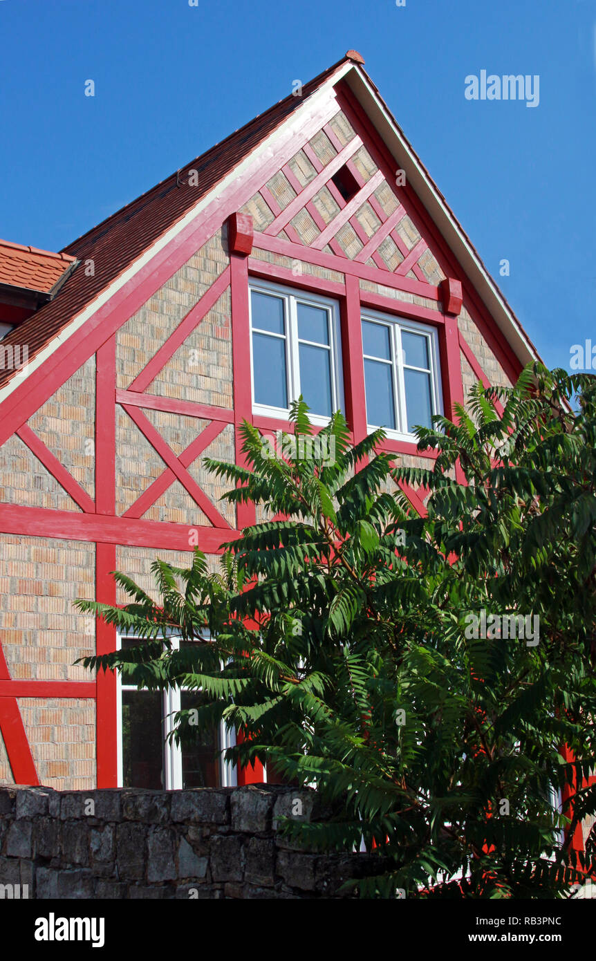 gable side of a half-timbered house in construction, with red painted ...