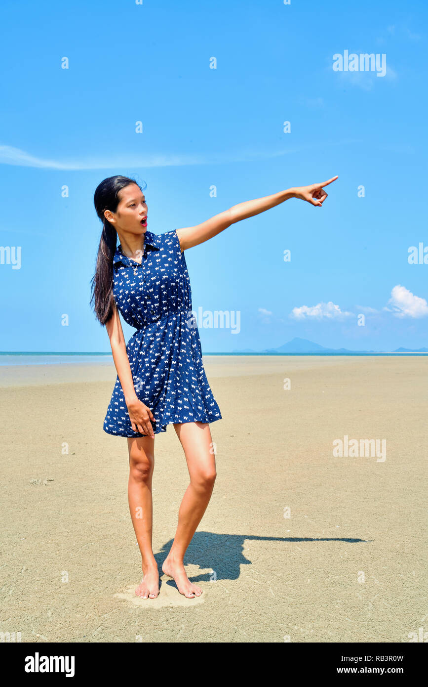 Beautiful woman posing - pointing somewhere, looking away and shocked ...