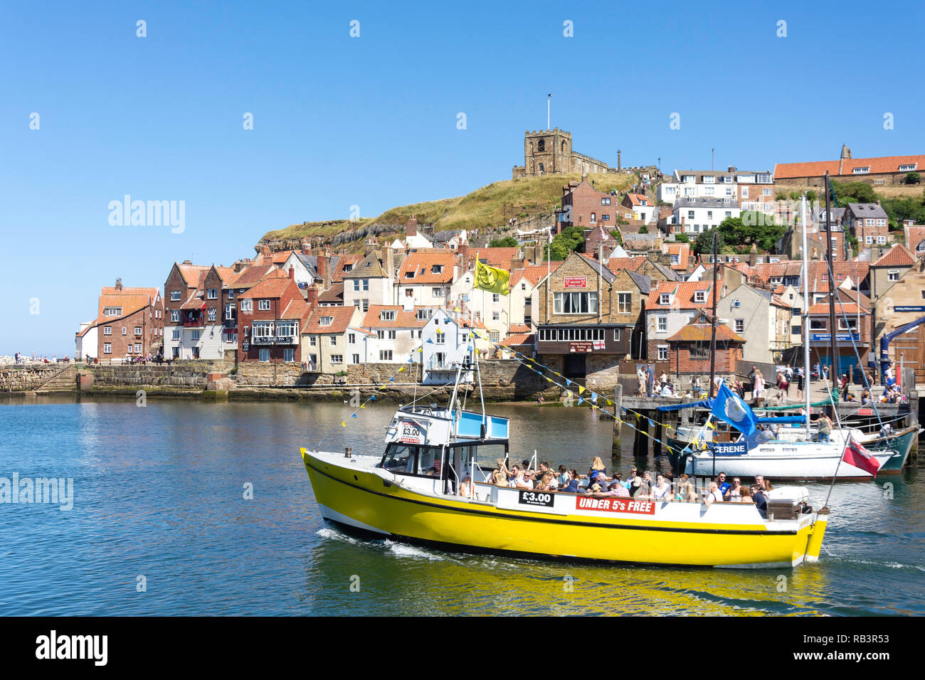 The Yellow Boat harbour cruise boat and East Cliff, Whitby, North ...