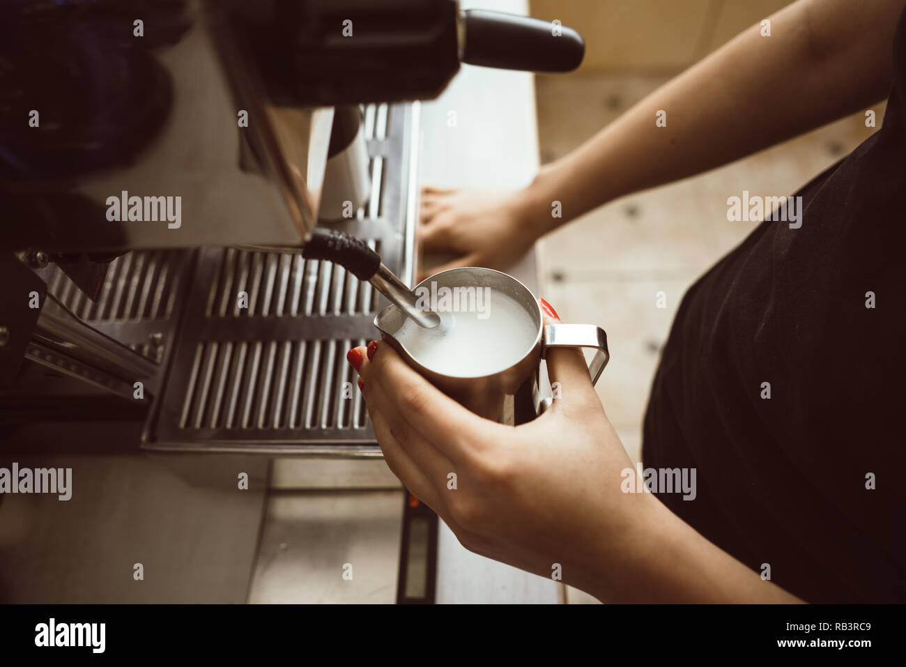 The barista is making boiled milk. He uses special coffee machine for it Stock Photo - Alamy