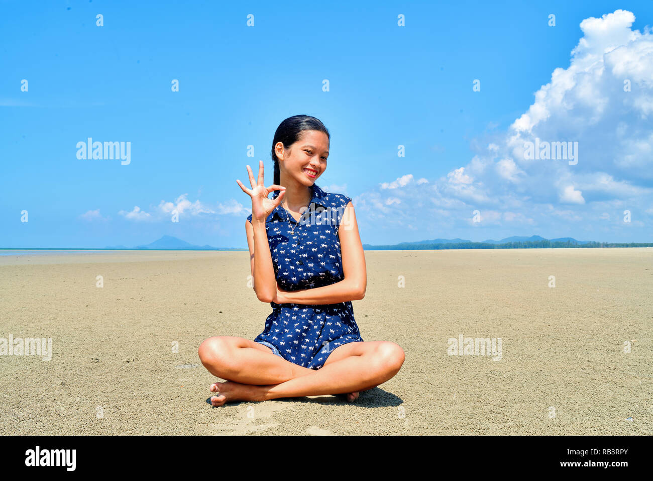 Beautiful woman posing - sitting, smiling and sign gesture Stock Photo ...