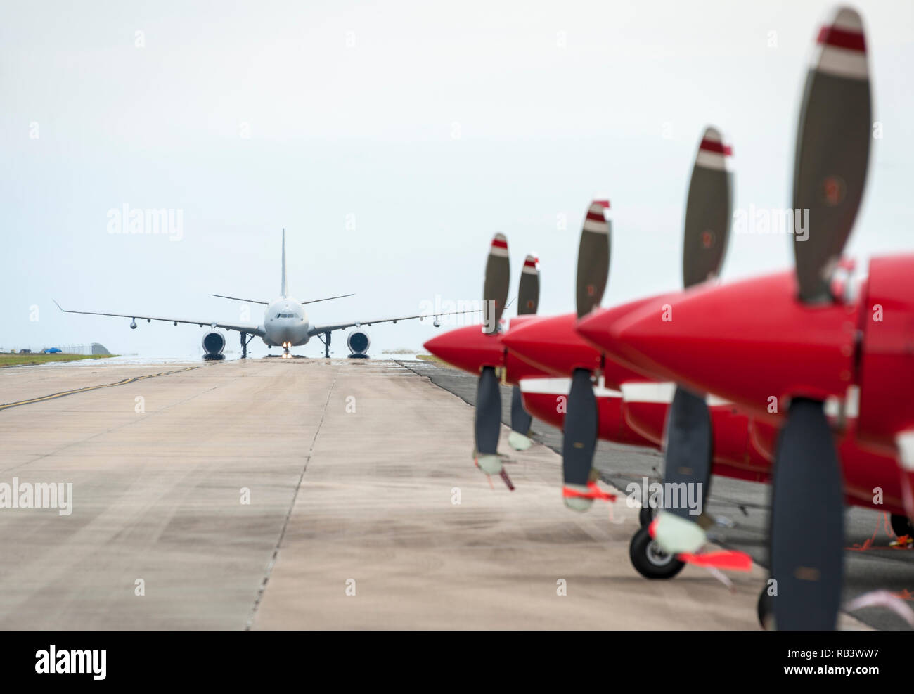 Jet airplane on runway with propeller driven aircraft in the foreground ...
