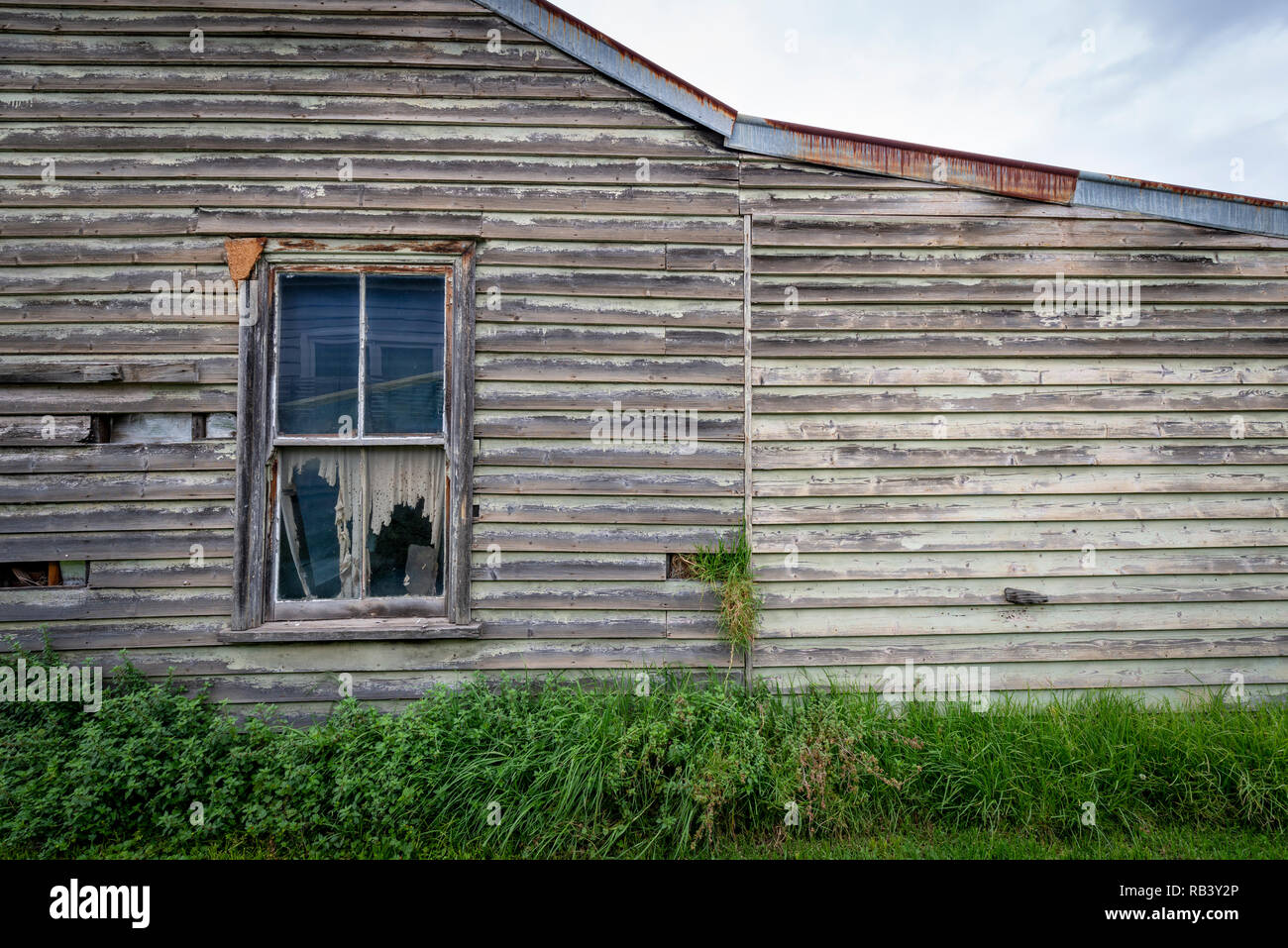 Side of an abandoned and weathered old house, soon to be torn down ...