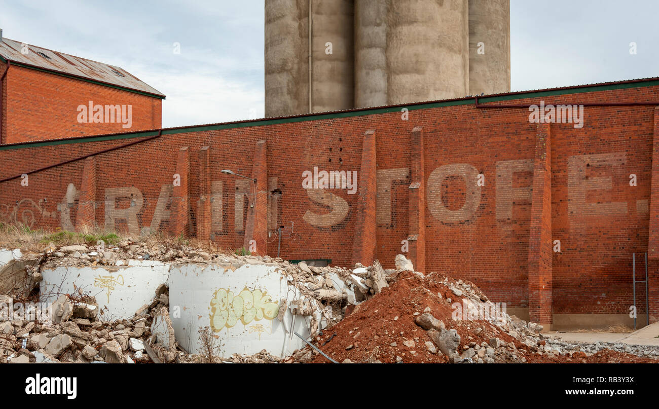 An old and faded Grain Store sign painted on a red brick wall with ...