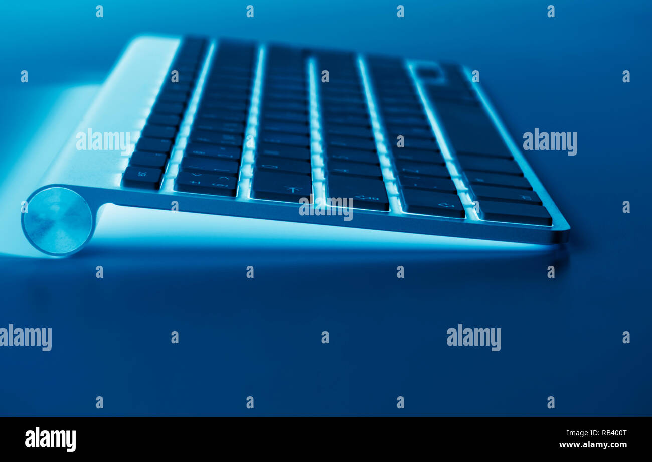 Business workplace with computer wireless keyboard on blue table ...