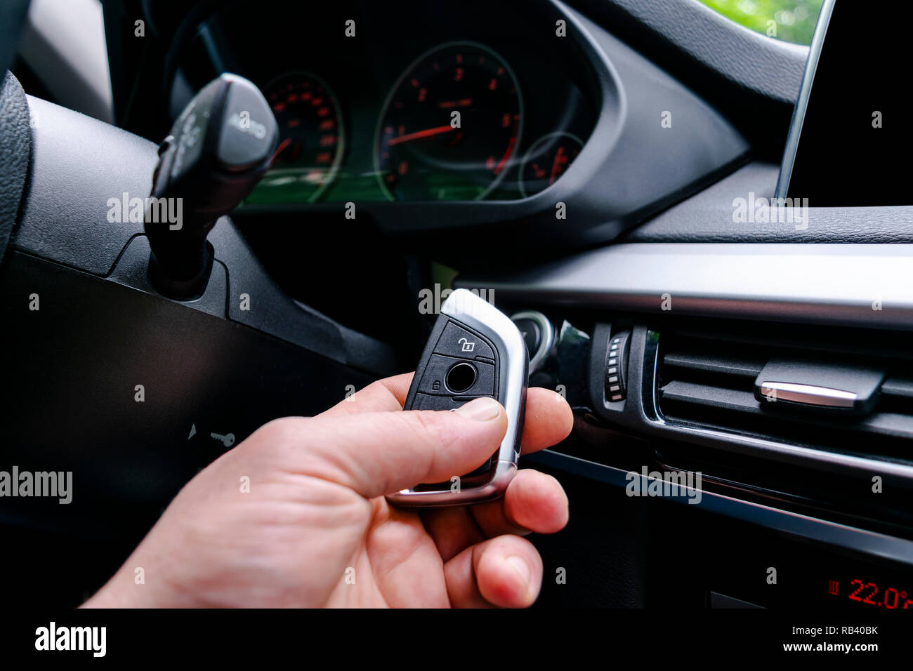 Closeup inside vehicle of man hand holding wireless key ignition. Start ...