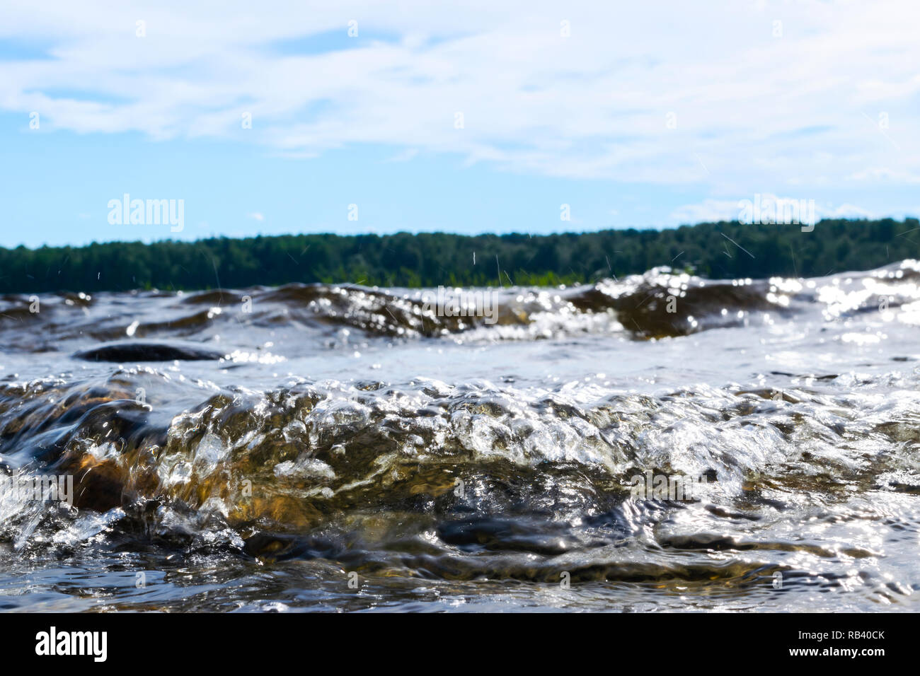 Big windy waves splashing over rocks. Wave splash in the lake against ...
