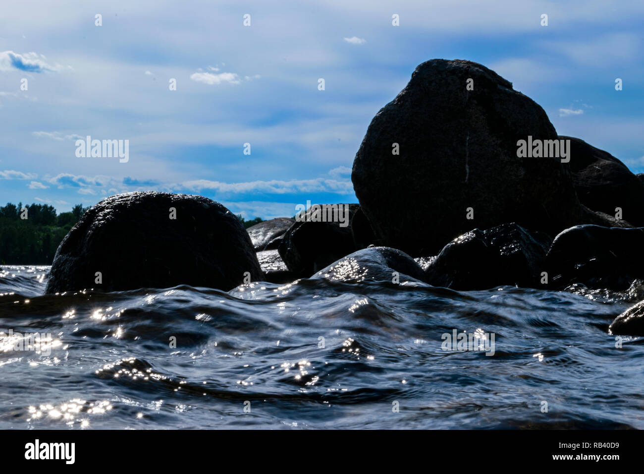 Big windy waves splashing over rocks. Wave splash in the lake against ...