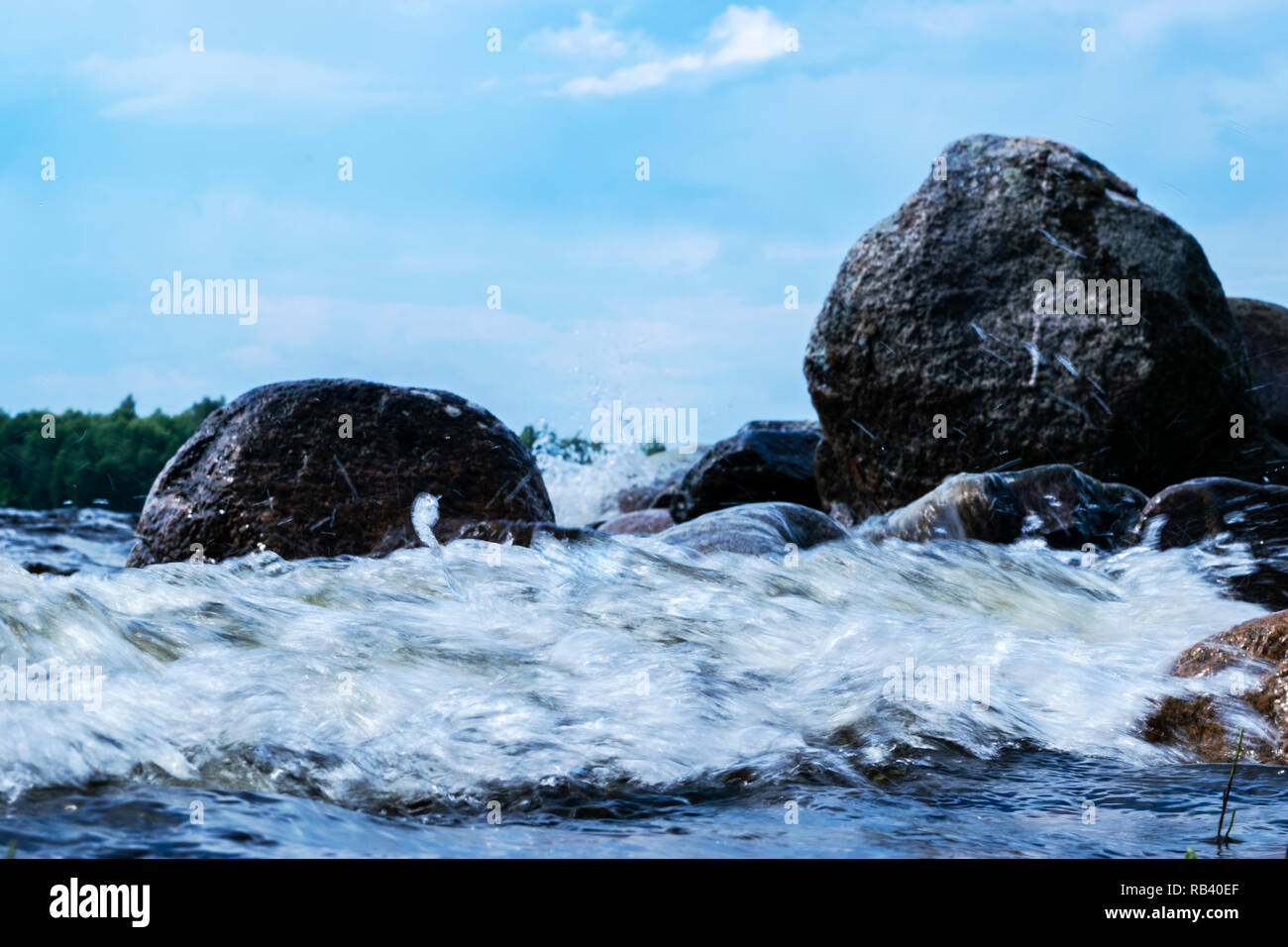 Big windy waves splashing over rocks. Wave splash in the lake against ...